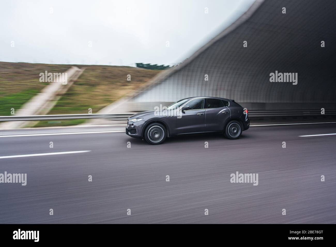 Grey offroader sport car driving under the bridge Stock Photo - Alamy