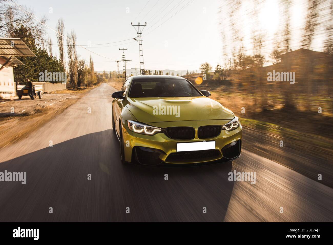 Yellow color hatchback driving on the road,front view Stock Photo - Alamy