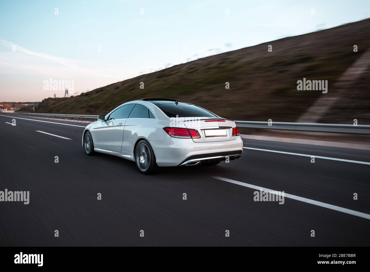 White business class sedan car driving on the highway with red xenon ...