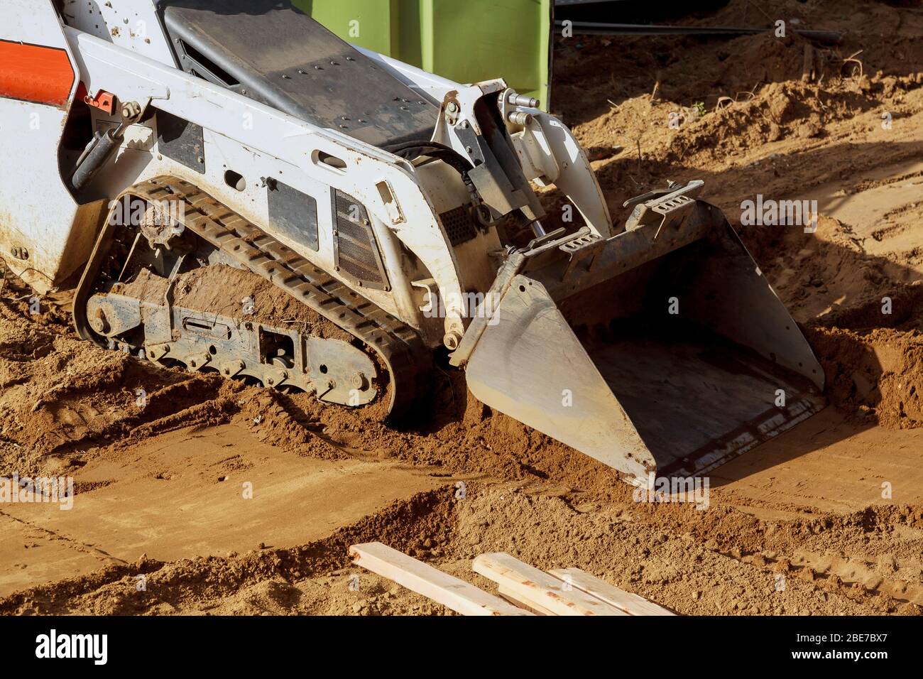 Mini bulldozer with earth doing landscaping works level the ground ...