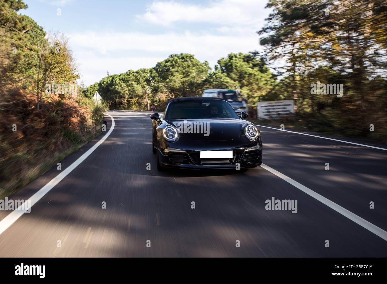 Black super model sedan car on the forest road in the summer time Stock ...