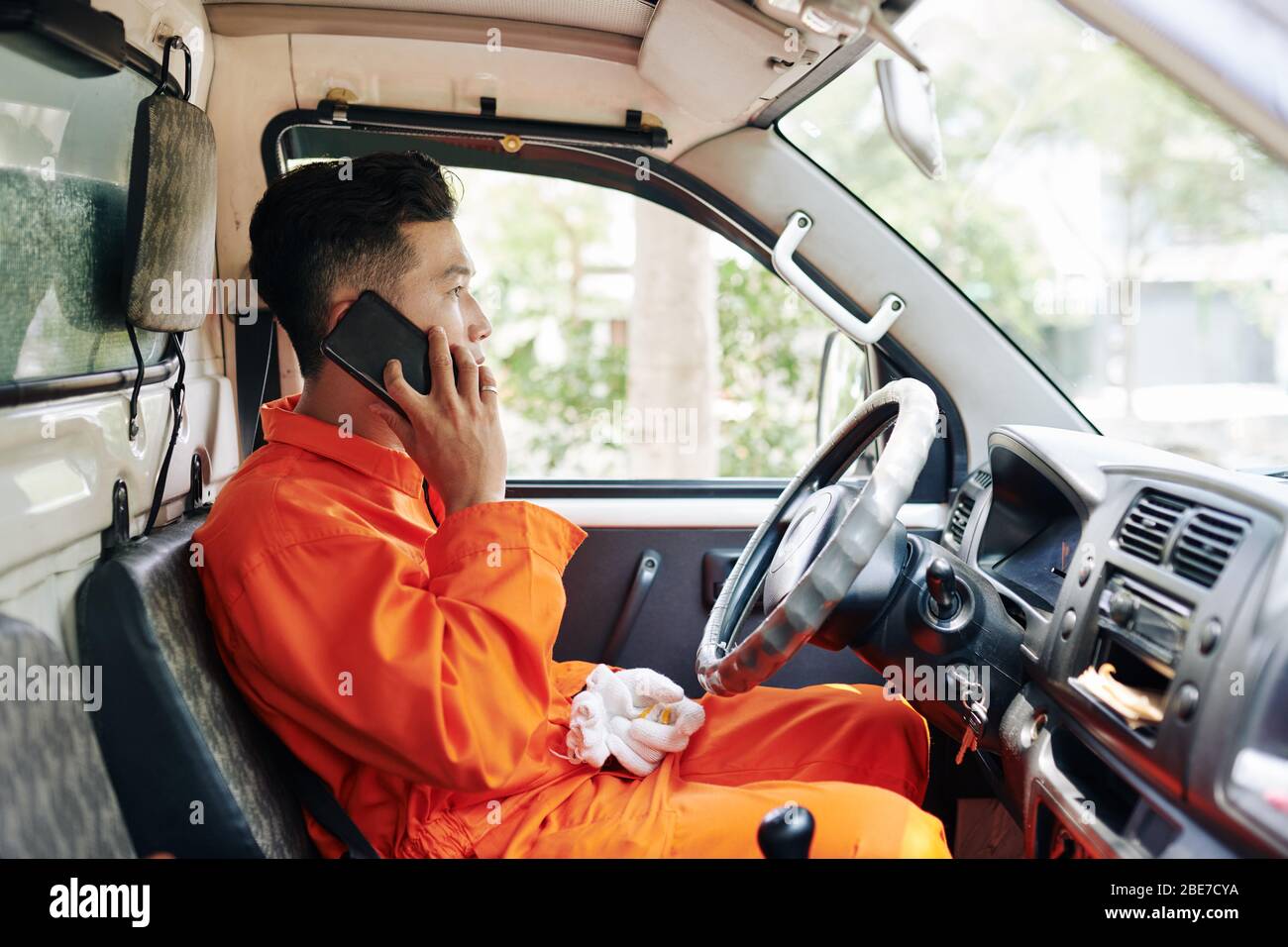 Moving service van driver in uniform talking on phone with client Stock ...
