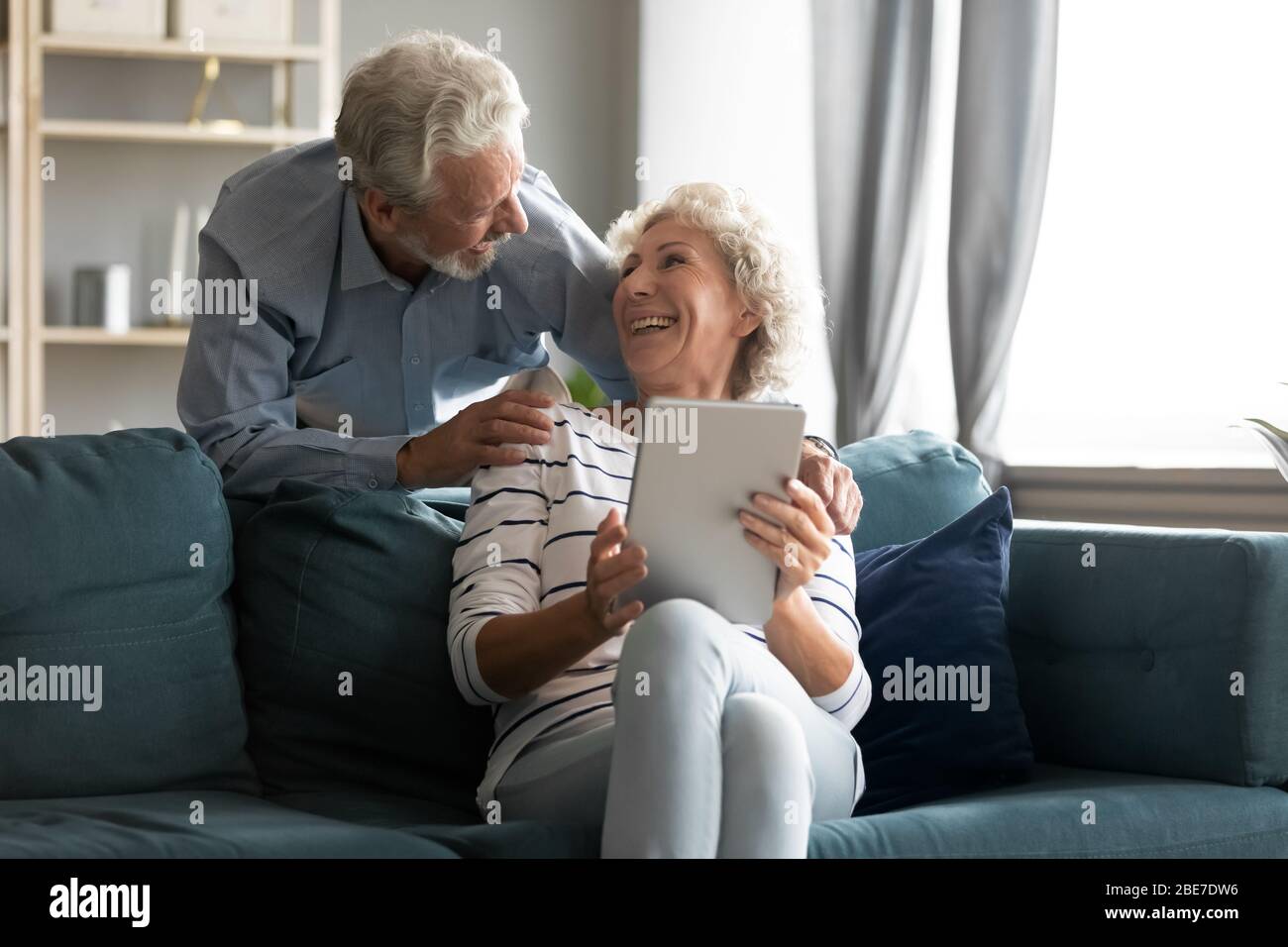 Excited older man and woman having fun with computer tablet Stock Photo ...