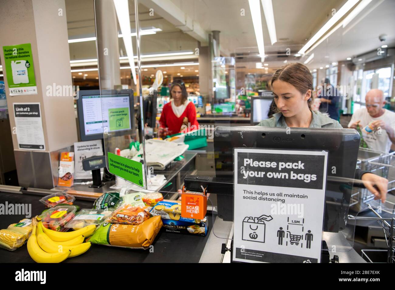 Girl checkout employee in Sydney woolworths supermarket stood behind ...