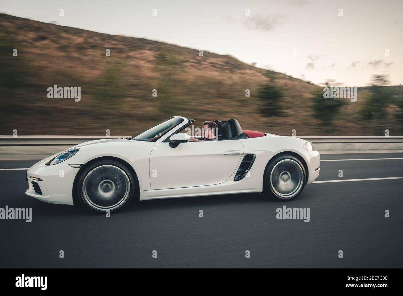 White super model cabriolet car driving on the highway in the dusk ...