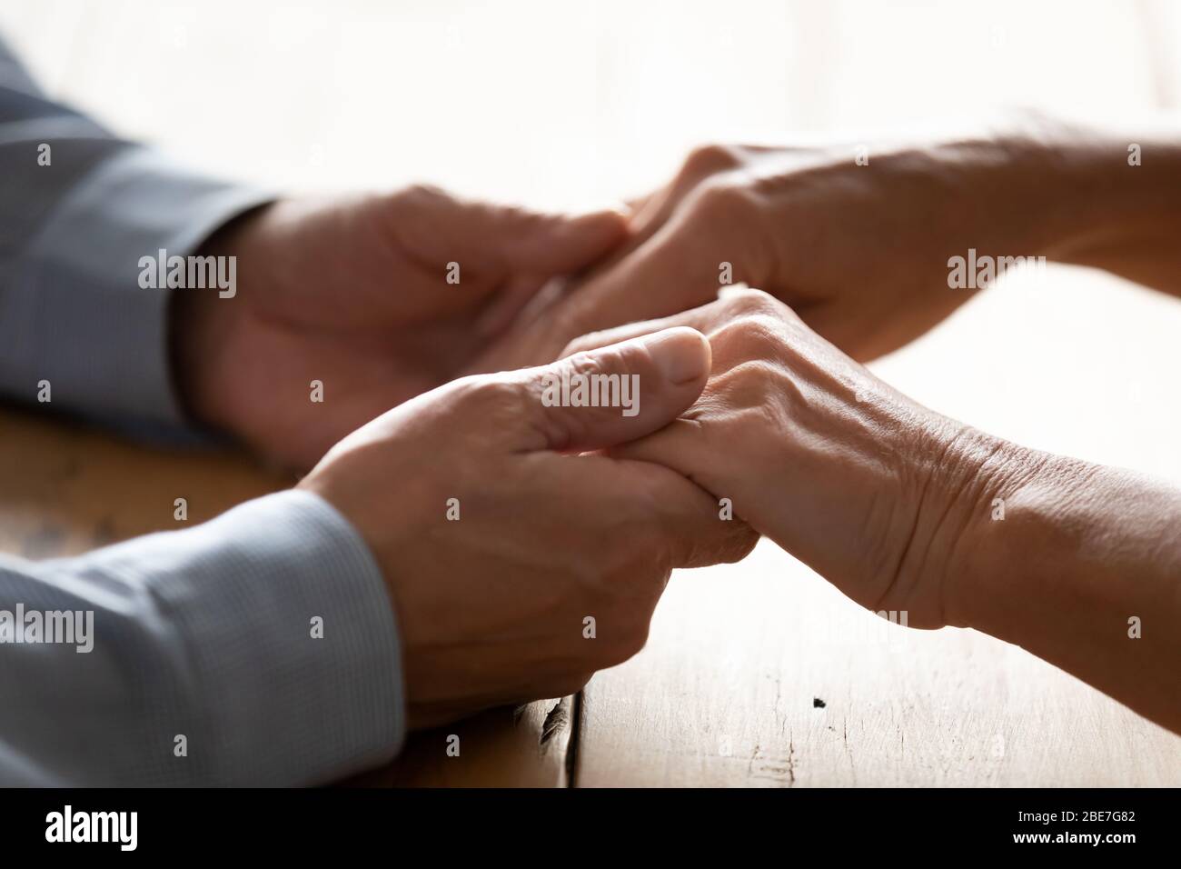 Close up older husband supporting wife, holding hands Stock Photo - Alamy