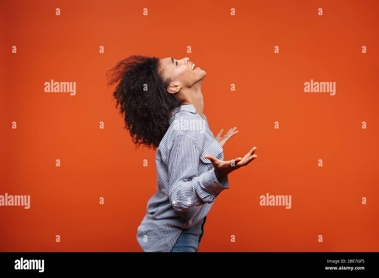 Side view of a young african woman pleading isolated over red ...