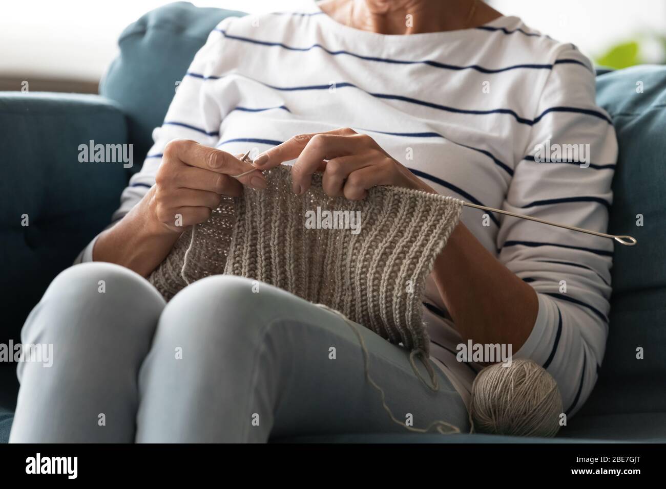 Close up older woman knitting, sitting on sofa at home Stock Photo - Alamy