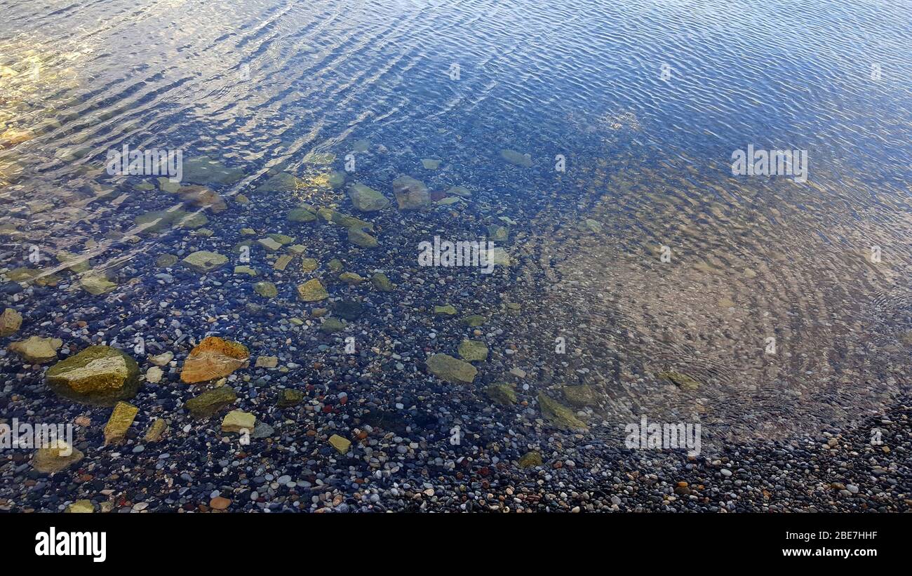 Stone beach and clear sea Stock Photo - Alamy