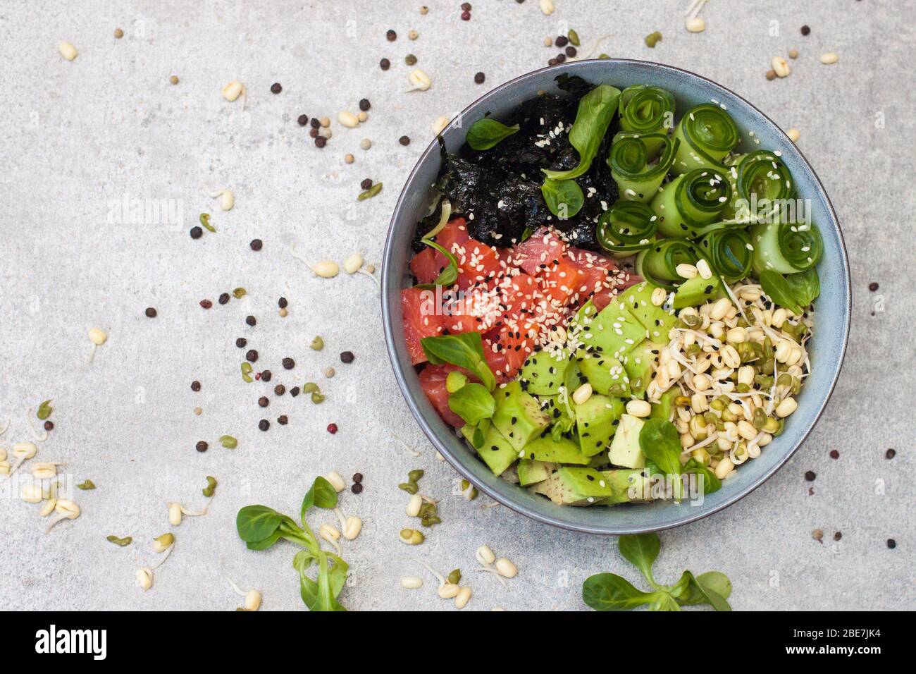 Poke bowl with smoked salmon, cucumber, avocado, sea kale, bean sprouts ...