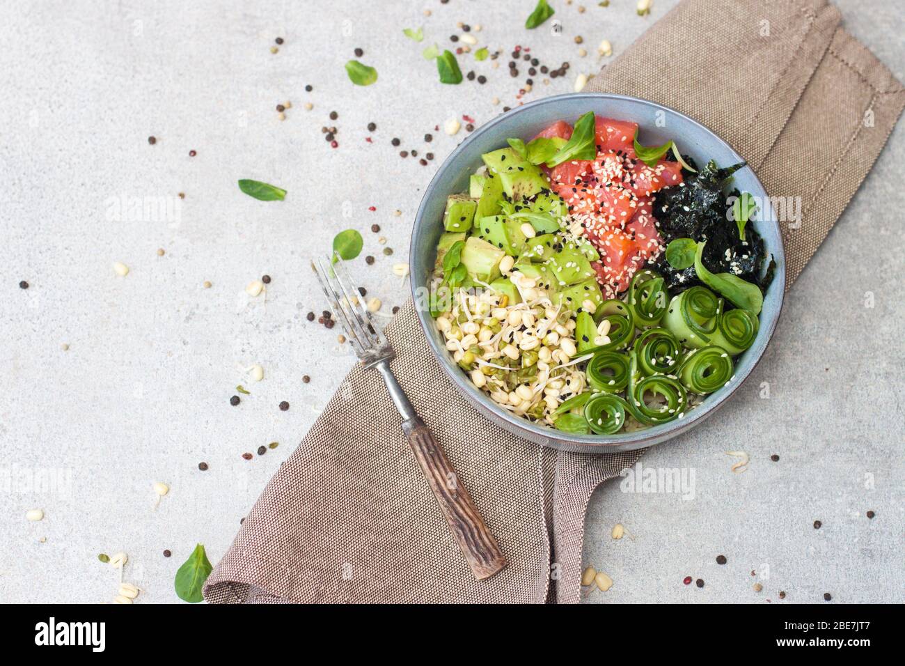 Poke bowl with smoked salmon, cucumber, avocado, sea kale, bean sprouts ...