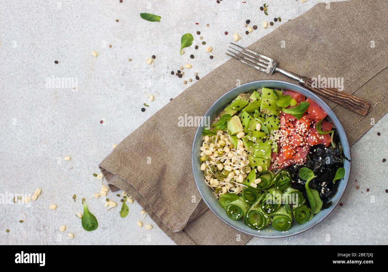 Poke bowl with smoked salmon, cucumber, avocado, sea kale, bean sprouts ...