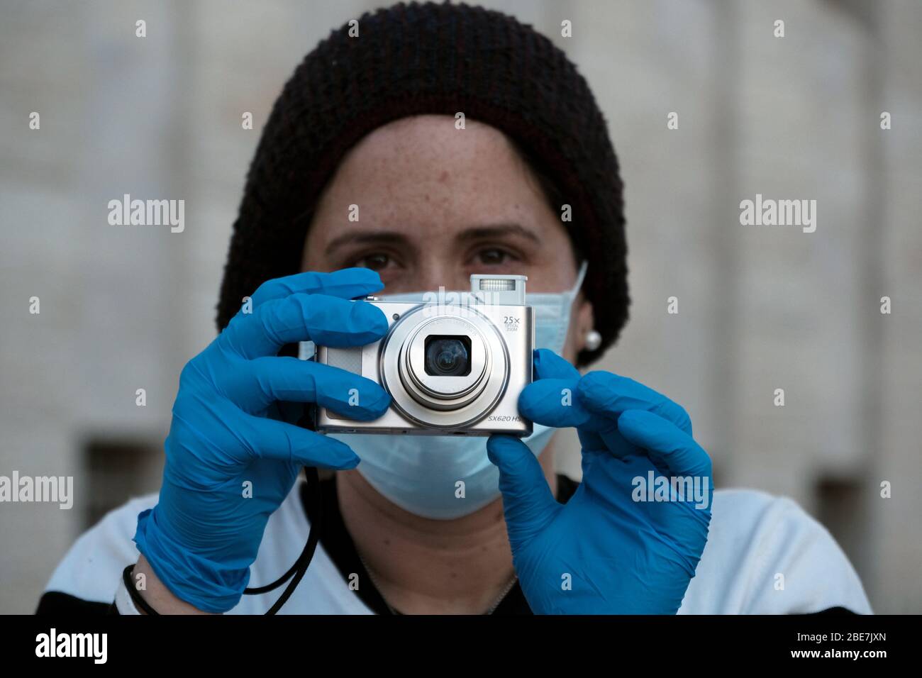 An ultra orthodox Jewish woman wearing protective mask and latex gloves ...