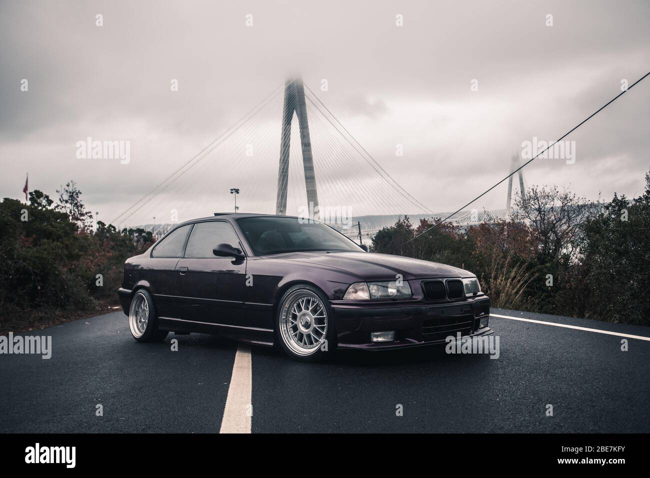 Black sedan car, red lights on in the parking on the road,front view ...