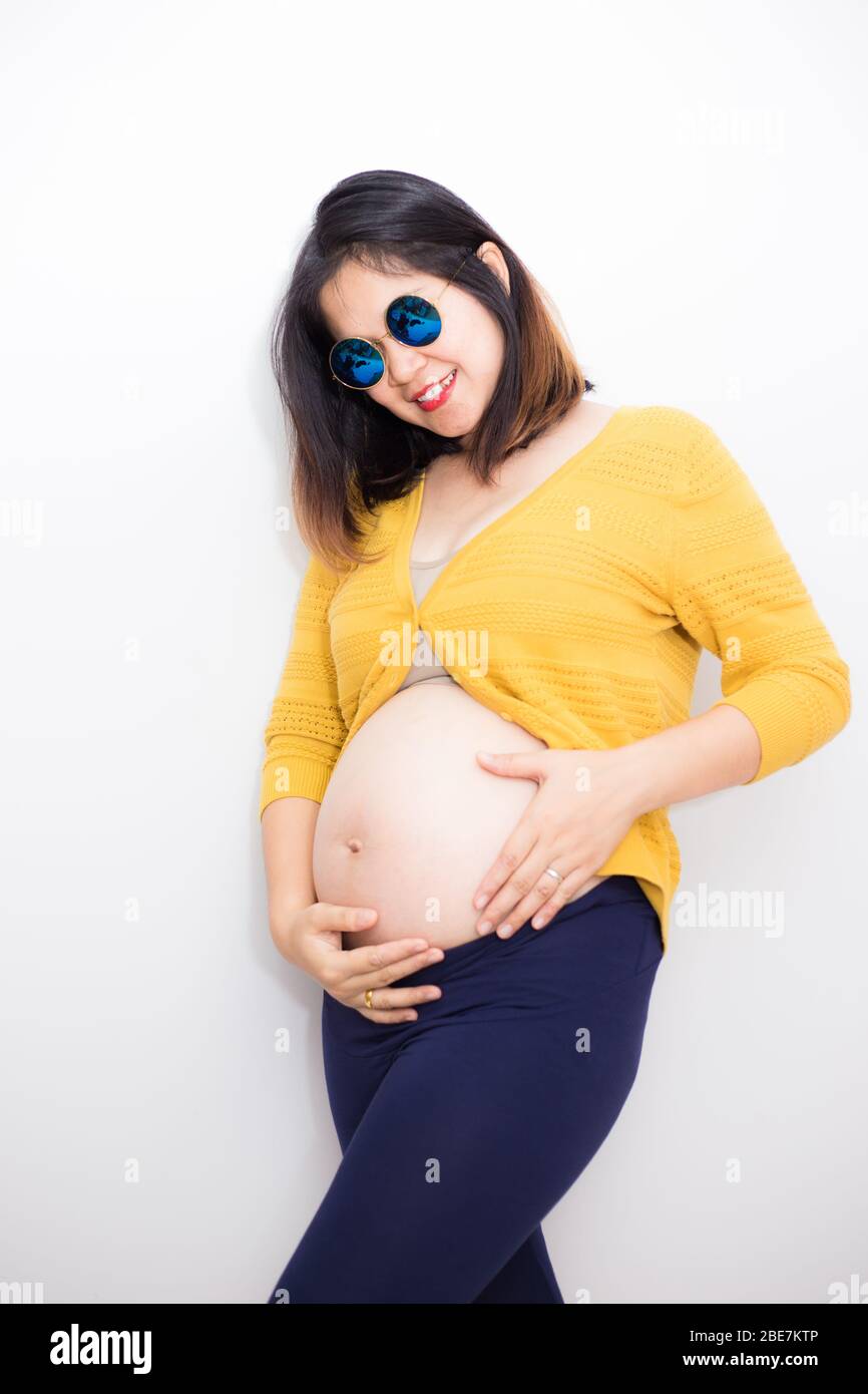 Joyful smiling pregnant women standing on white background expectation ...
