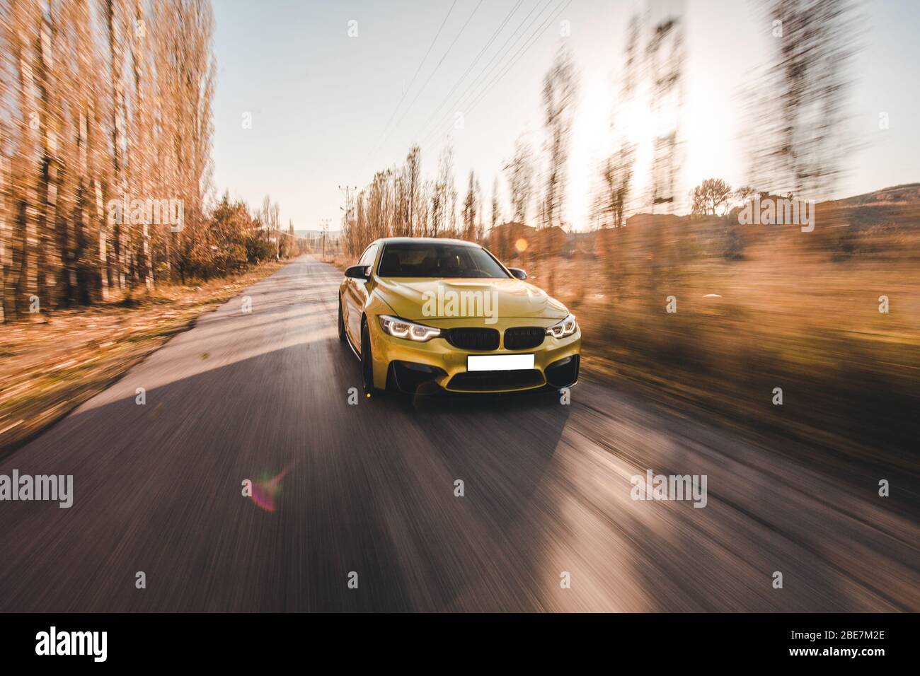 Yellow color hatchback driving on the highway across forest Stock Photo ...