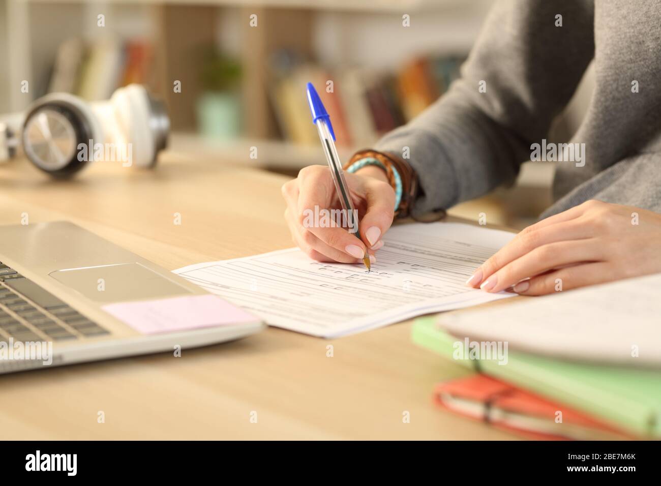 Close up of student girl hands filling out form document sitting on a ...