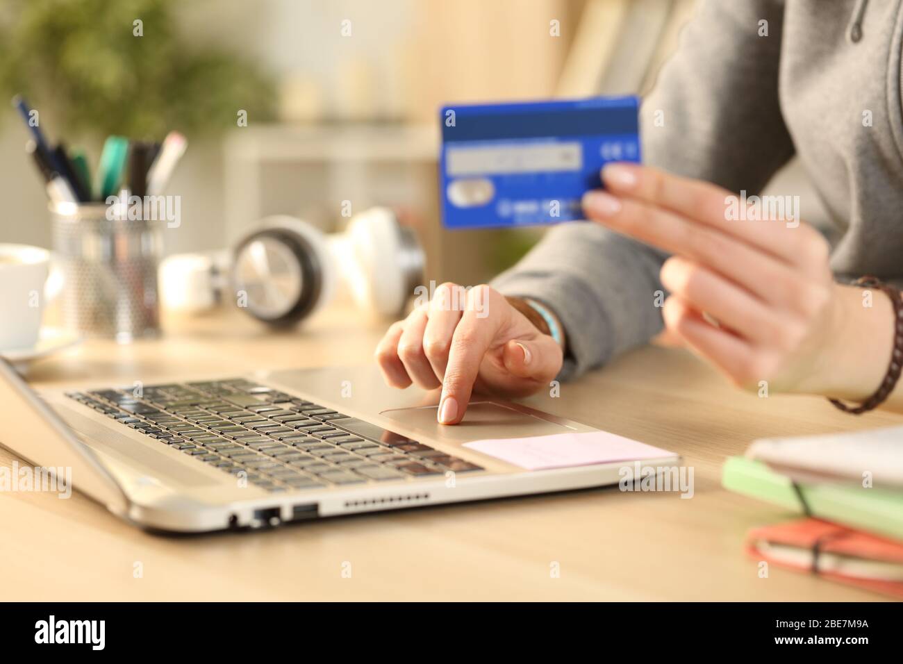 Close up of student girl hands paying online on laptop with credit card ...