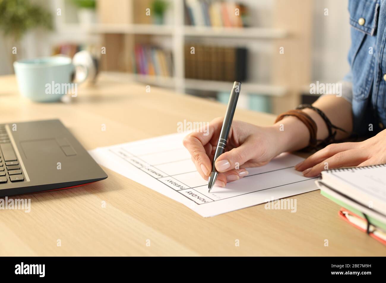 Close up of student girl hand writing schedule on weekly planner on a ...
