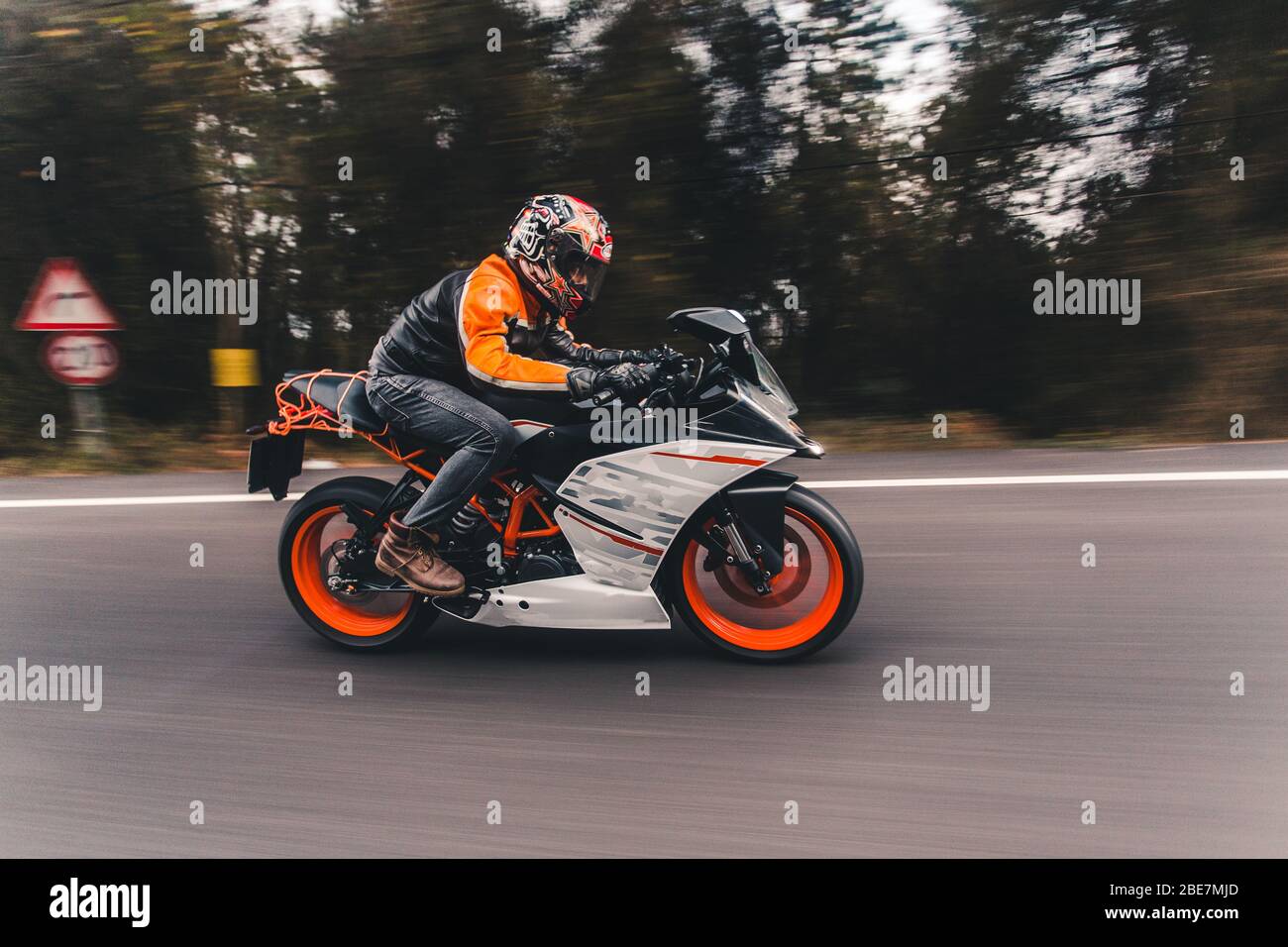 Driving an orange color motorcycle on the road Stock Photo - Alamy