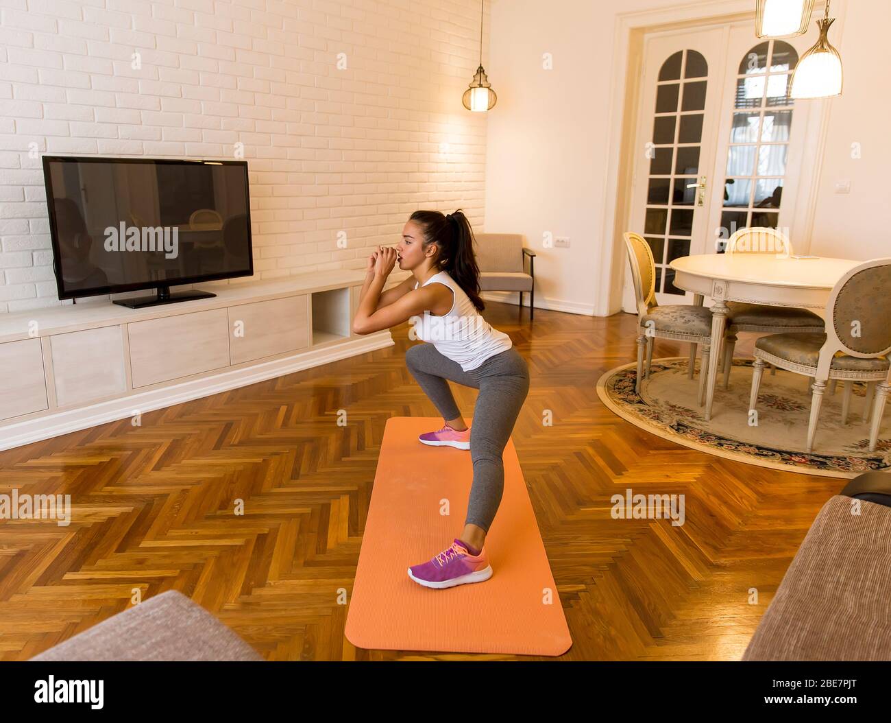 Cute young attractive woman practicing exercises at home Stock Photo ...