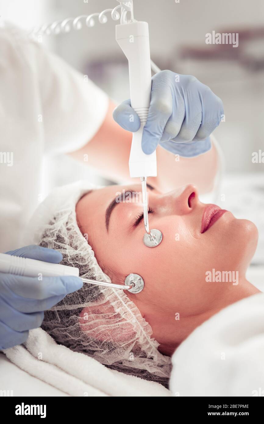 Facial deep cleansing. Woman lying in beauty salon and having facial ...