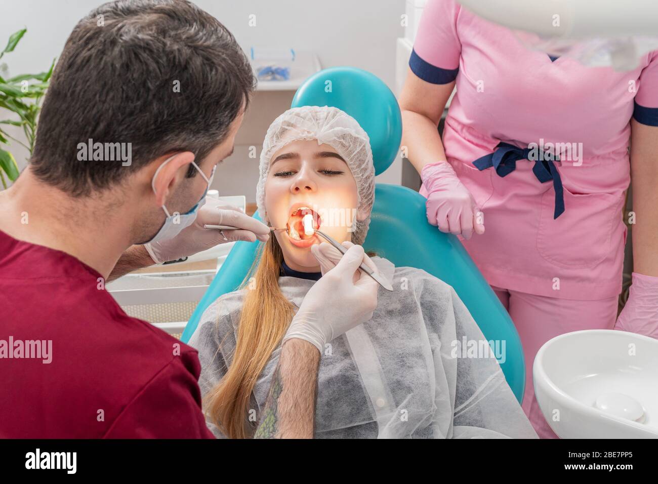 dentist puts down the cheek swab in the patient mouth open Stock Photo ...