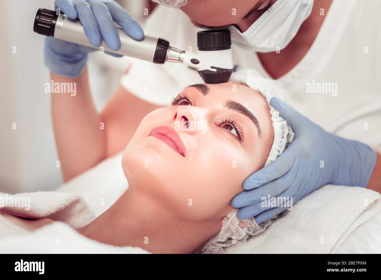 Cleansing face skin. Cosmetologist in gloves and white uniform ...