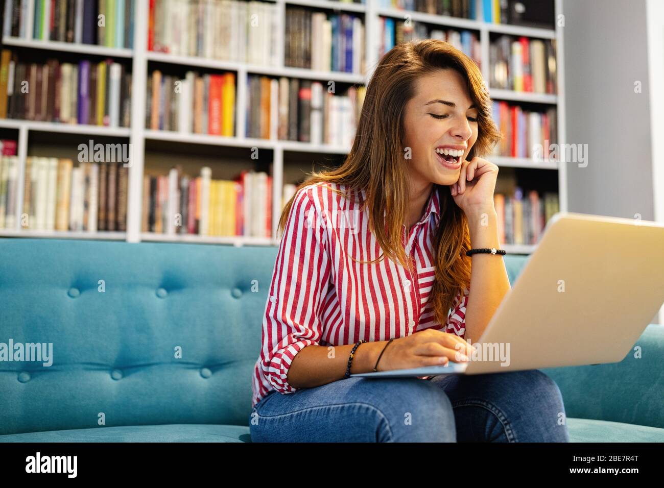 Happy young woman receiving good news on her notebook Stock Photo - Alamy