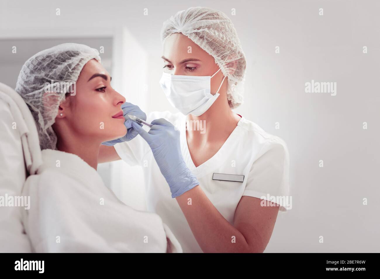 Mesotherapy injections. Cosmetologist wearing gloves and uniform doing ...