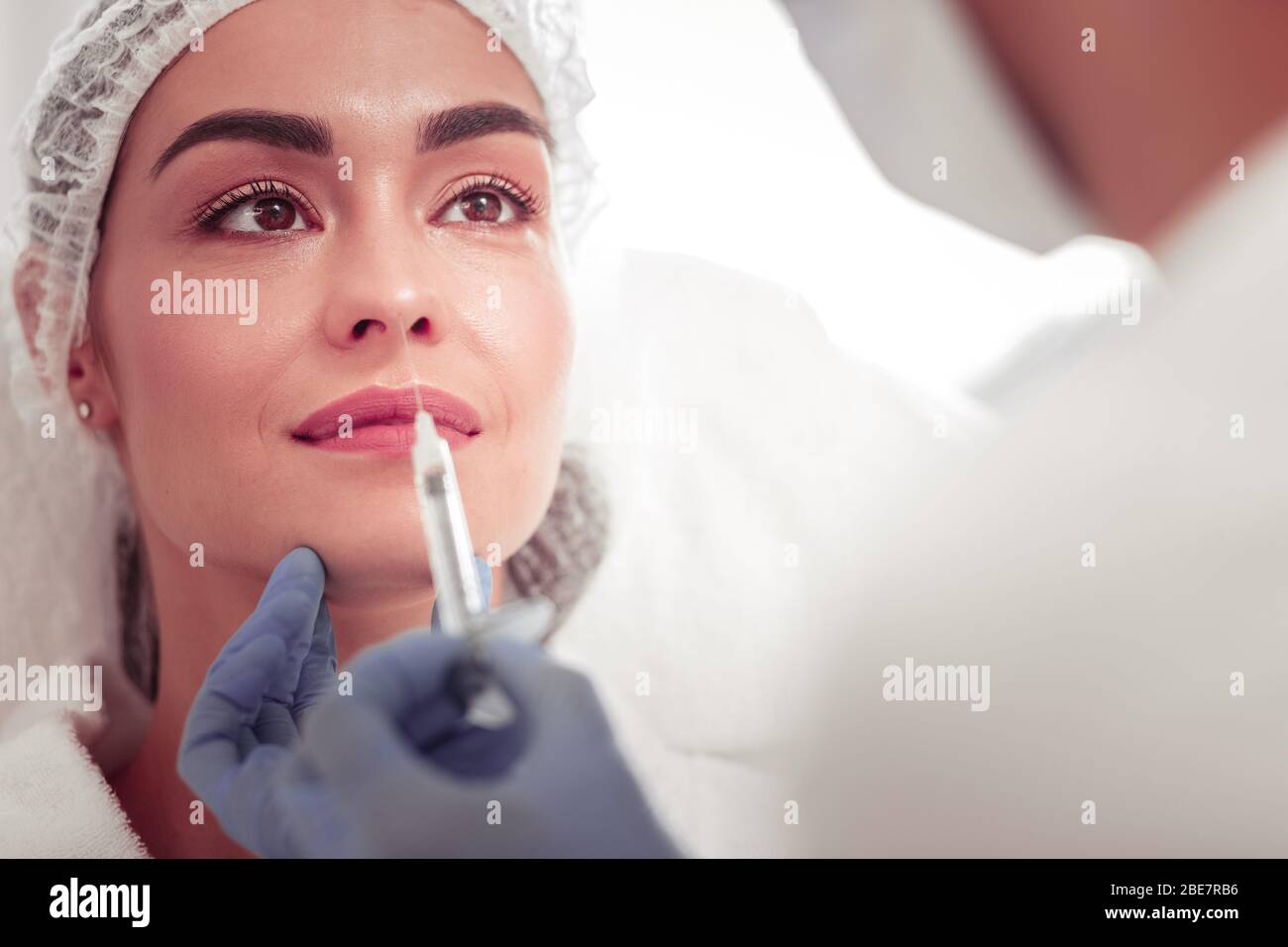 Injection after work. Dark-eyed beautiful young businesswoman having ...