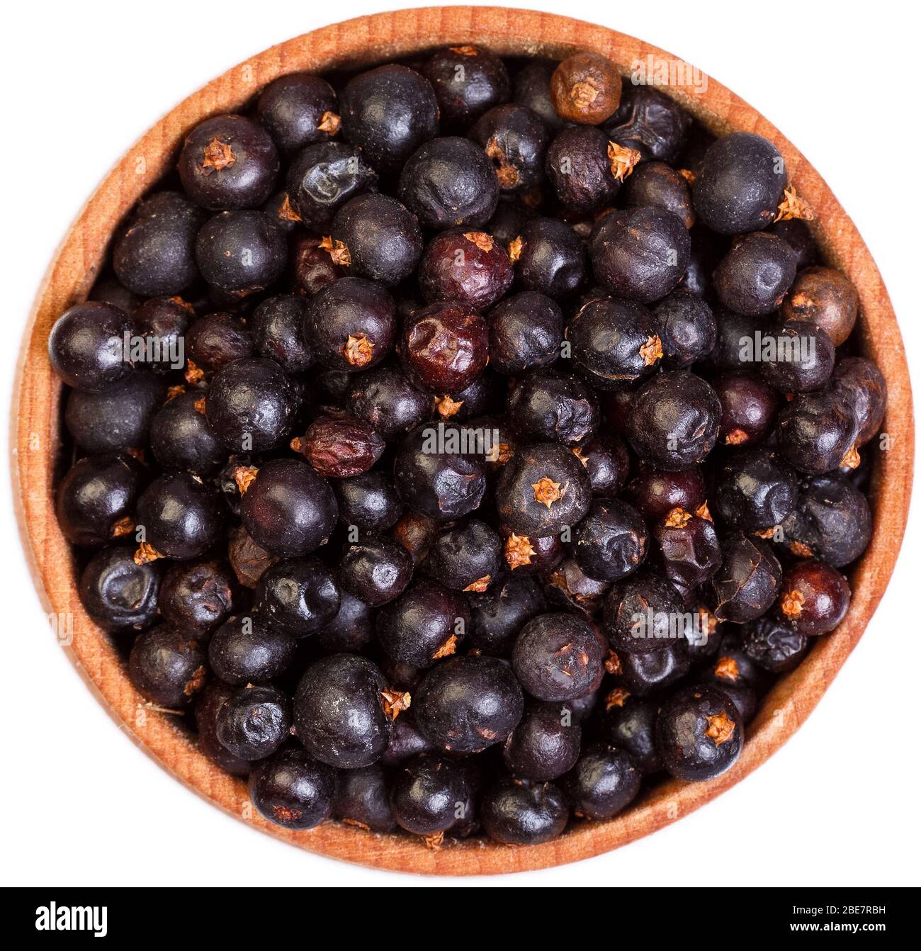 Dried Juniper berries in a small wooden bow isolated Stock Photo - Alamy
