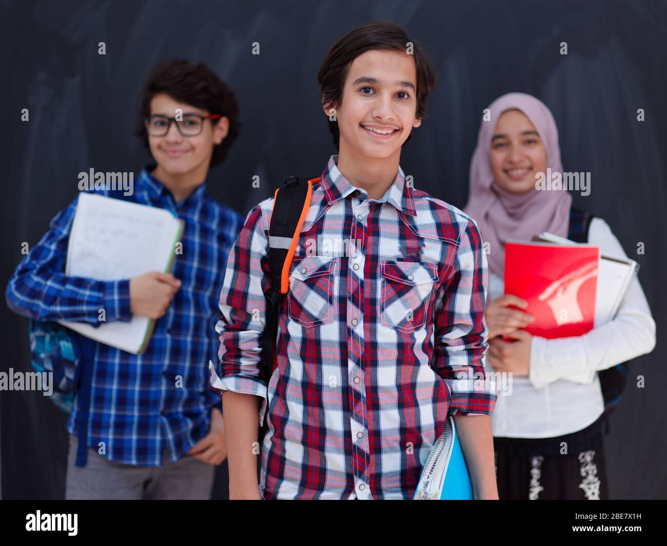 Arabic teenagers, students group portrait against black chalkboard ...