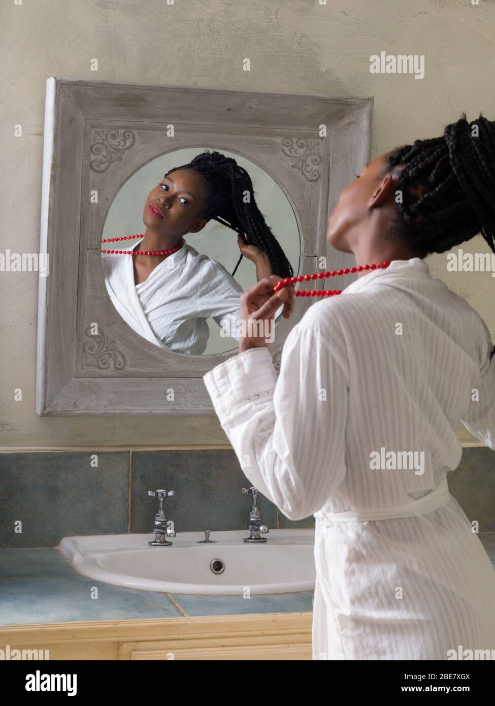 Pretty young african american woman doing her morning routine in front ...