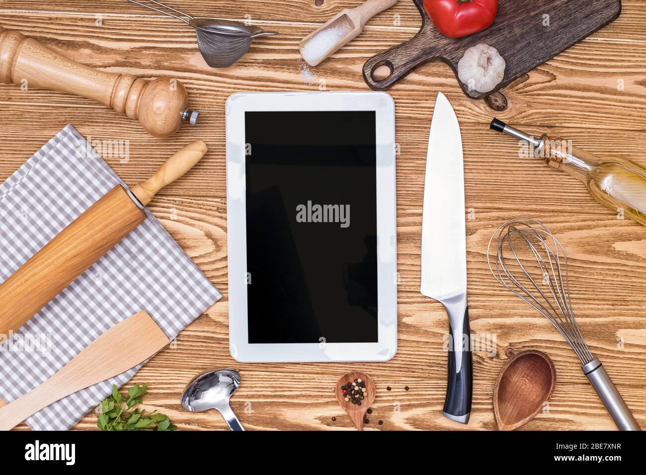 Tablet with blank screen and different kitchen and cooking utensils ...
