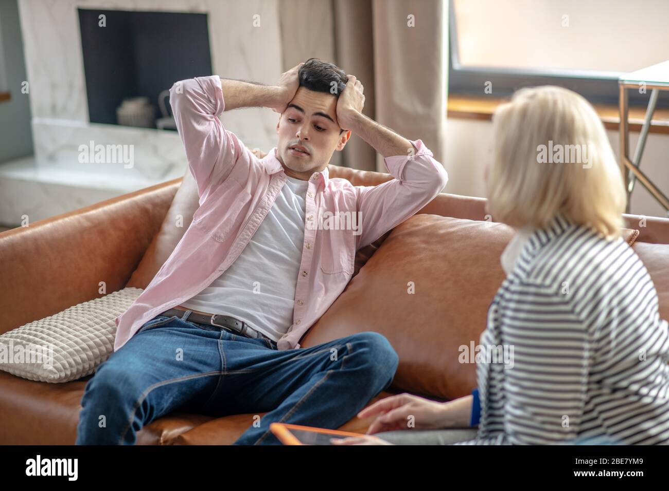 In despair. Young man in a pink shirt feeling desperate Stock Photo - Alamy