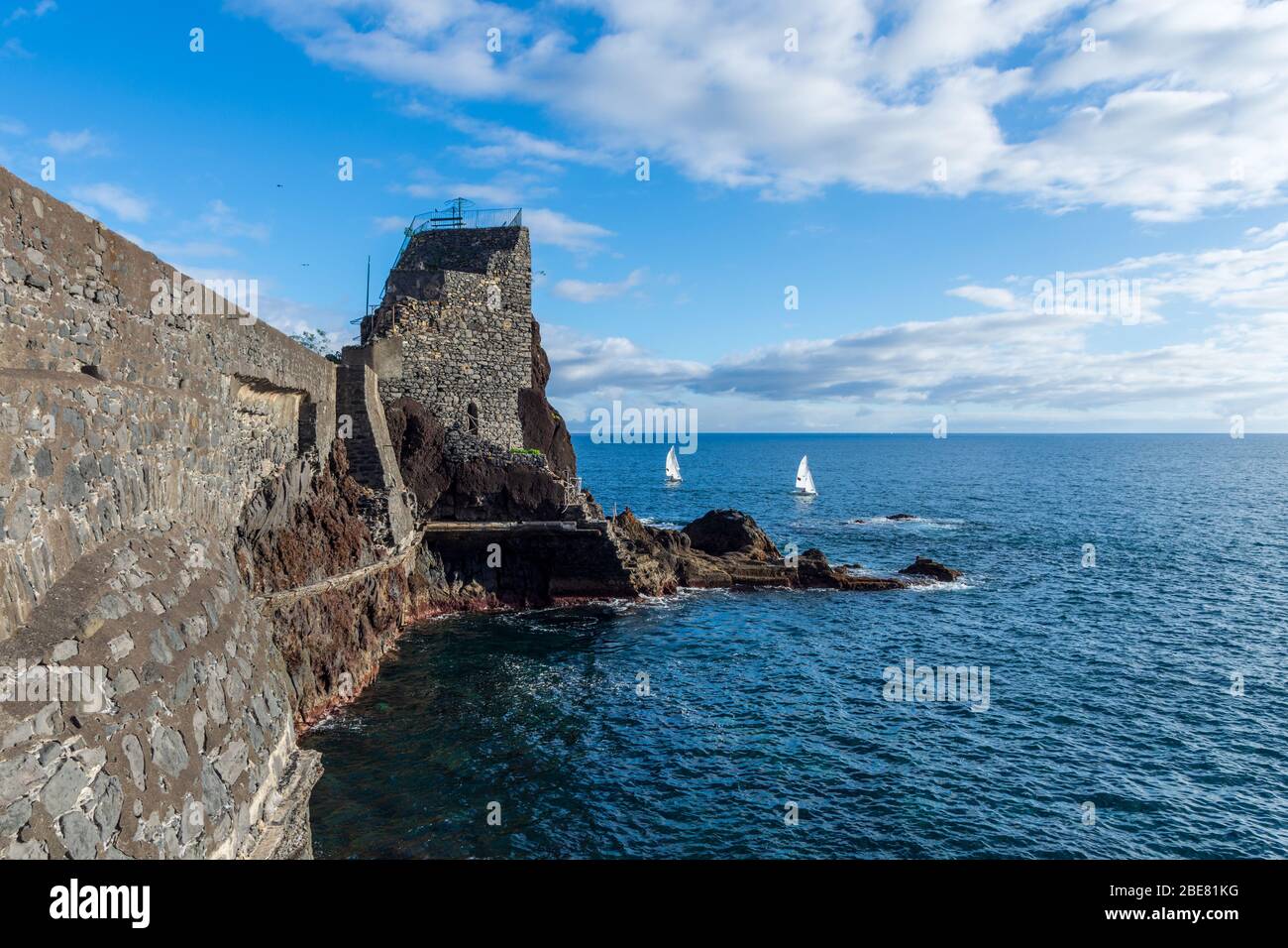 Sailboats on the sea outside the old part of Funchal harbor with ...