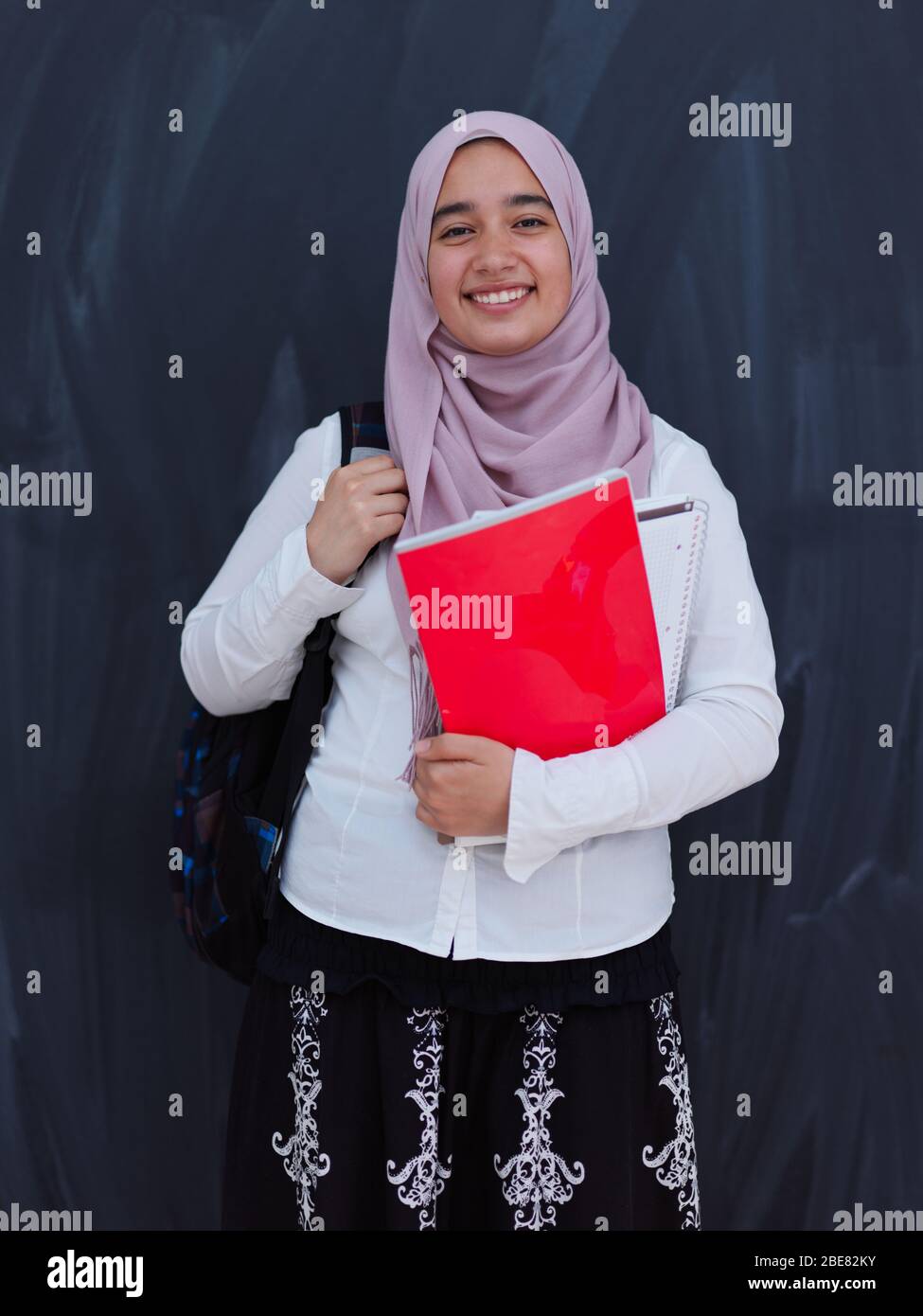 portrait of happy female middle eastern university student against ...