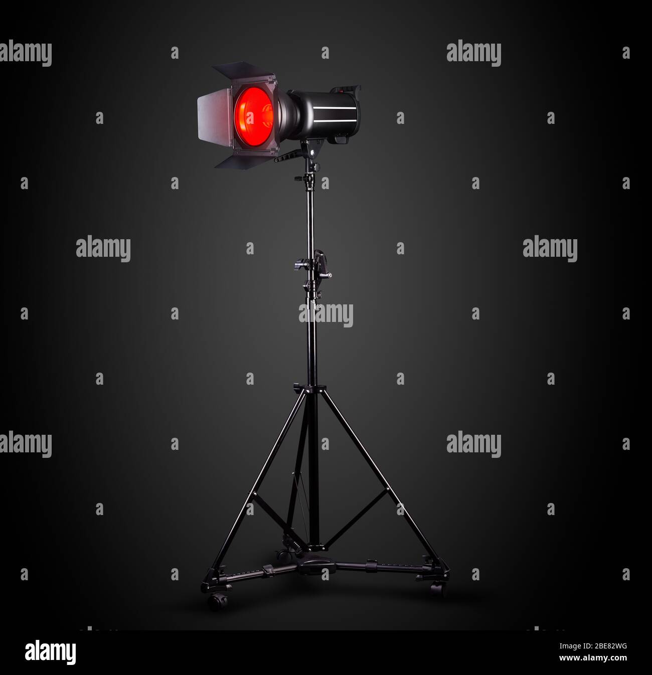 Photography studio flash on a lighting stand isolated on black ...