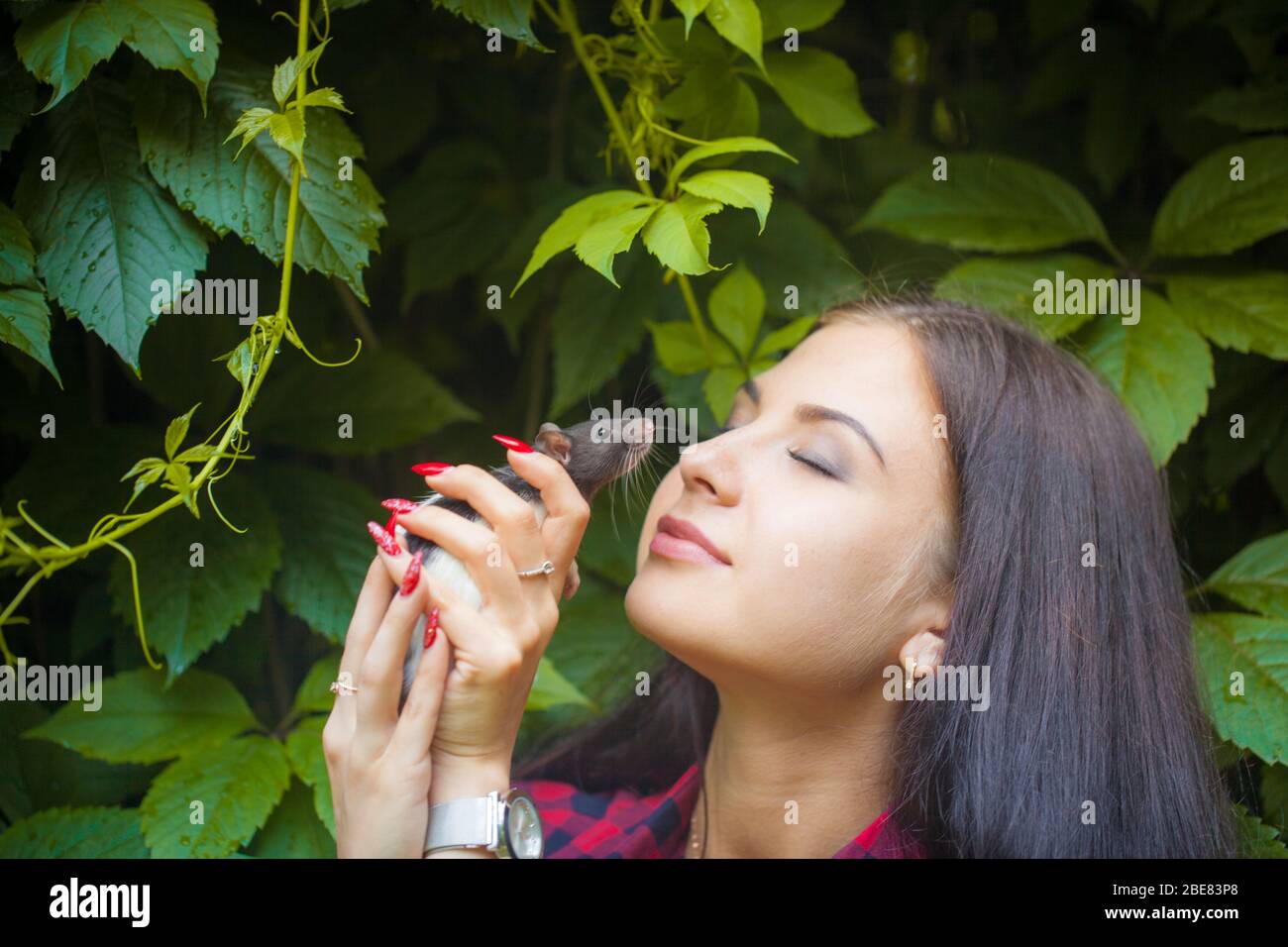 Witch conjures in the woods with a familiar. Brunette girl with a rat ...