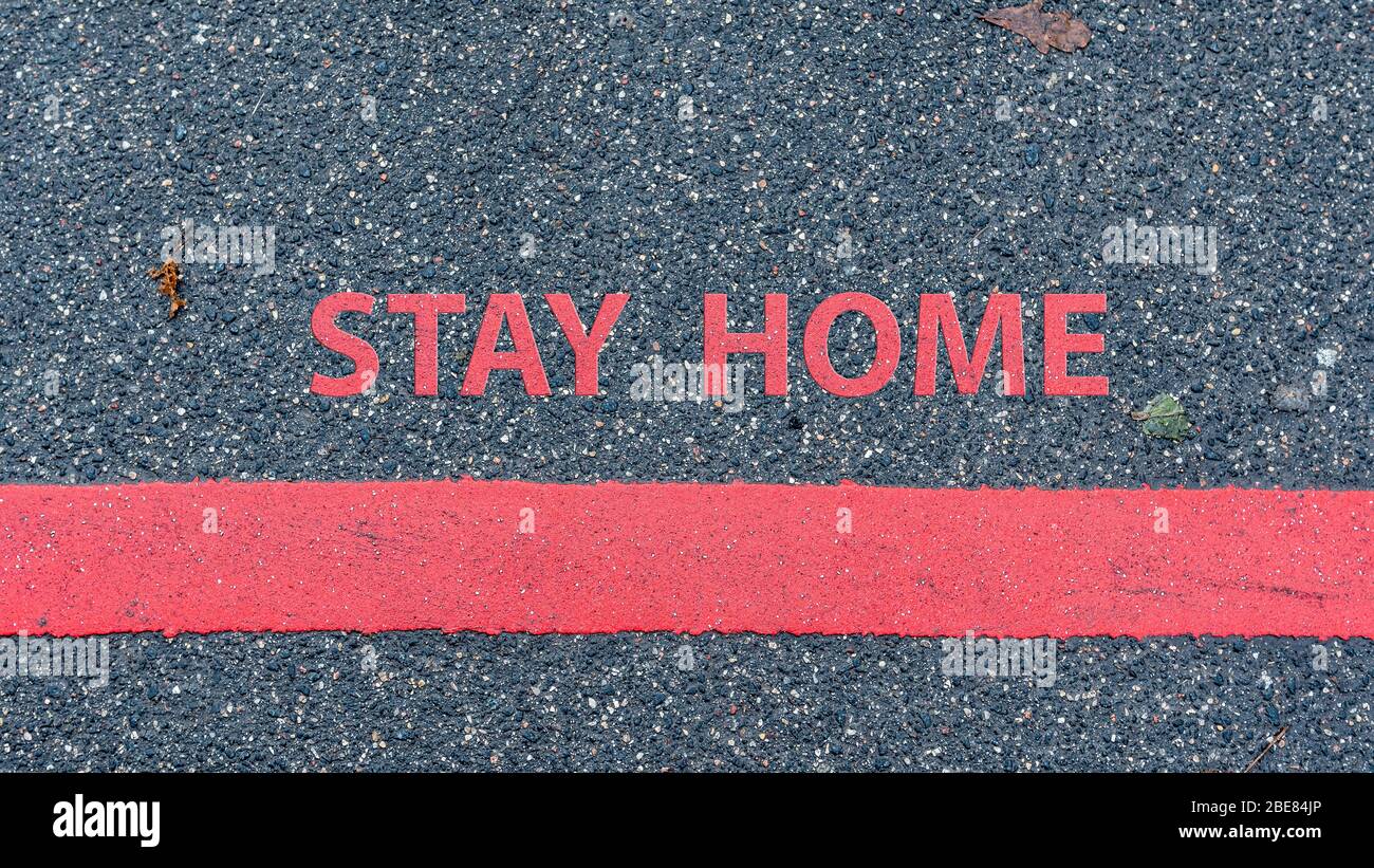 top View of the asphalt road with red line and text STAY HOME ...