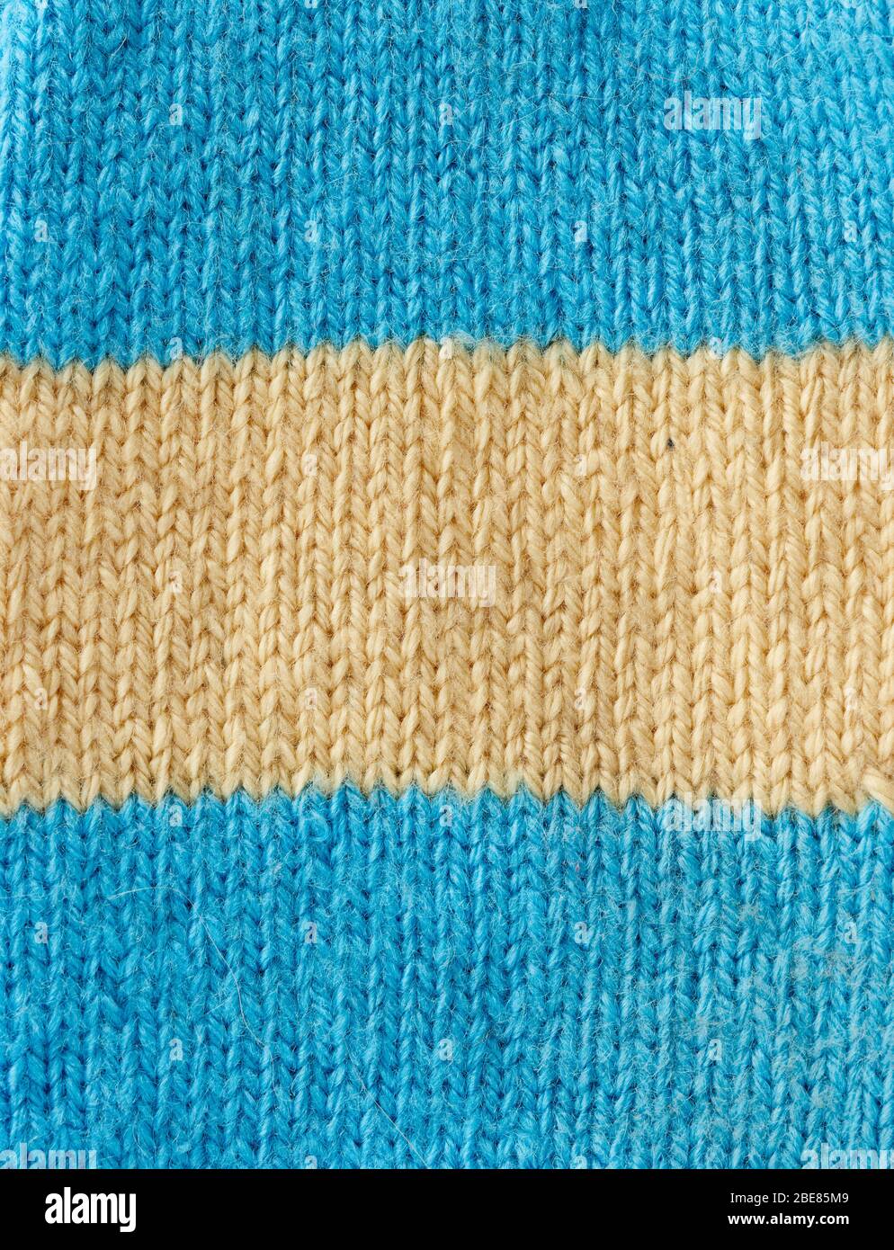 fragment of knitted fabric from blue and beige wool, pigtail pattern ...