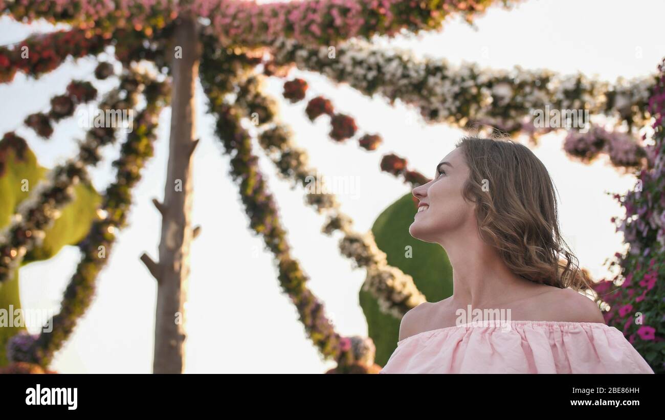 Girl on the background of hanging daisies of fresh flowers in a city ...