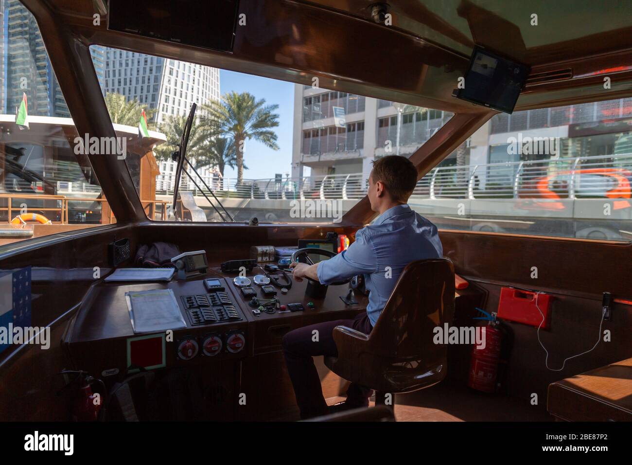 A male captain of watercraft boat at the helm of a boat Stock Photo - Alamy