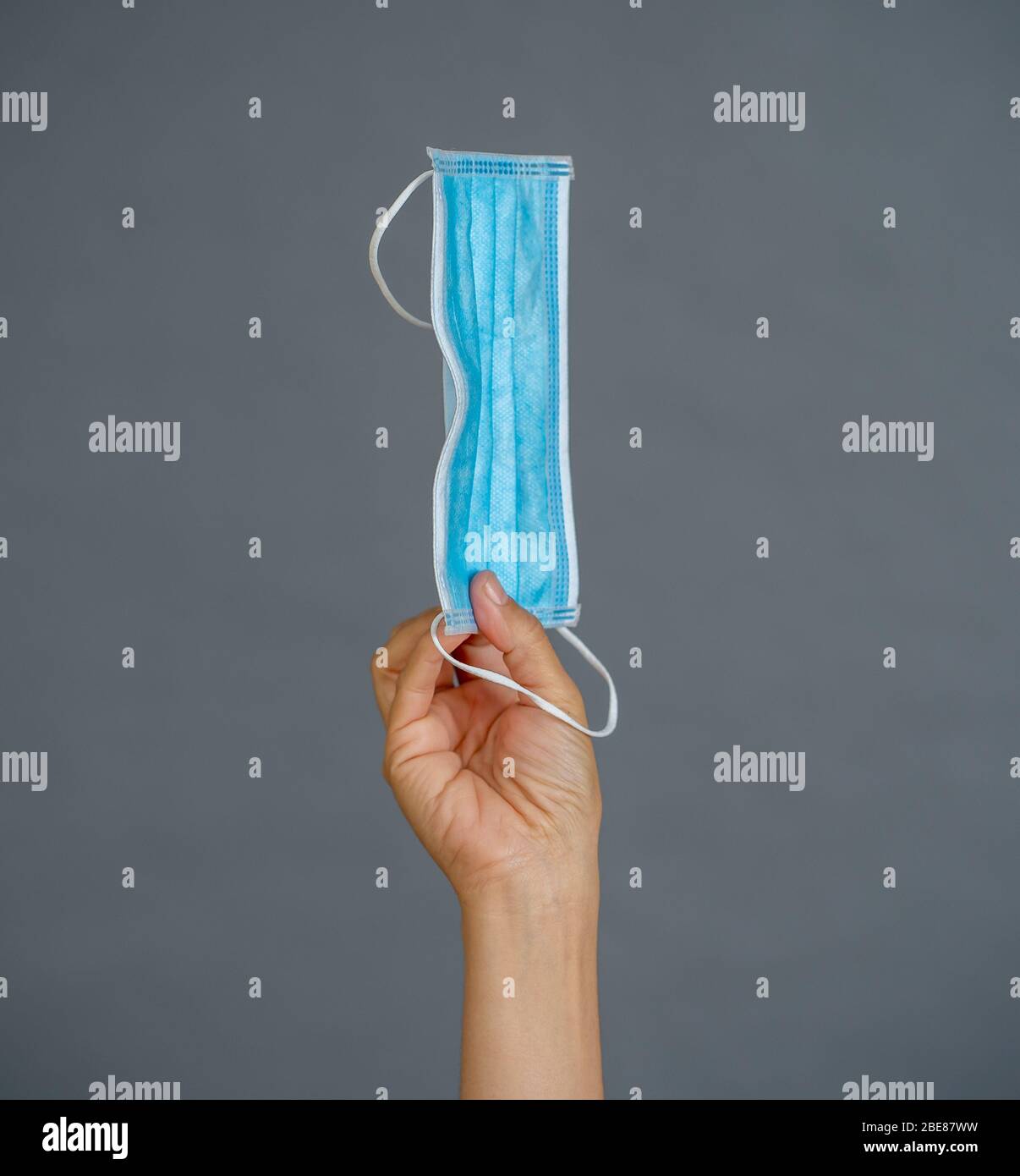 Coronavirus disease outbreak. Hand holding face surgical mask. Stop the ...