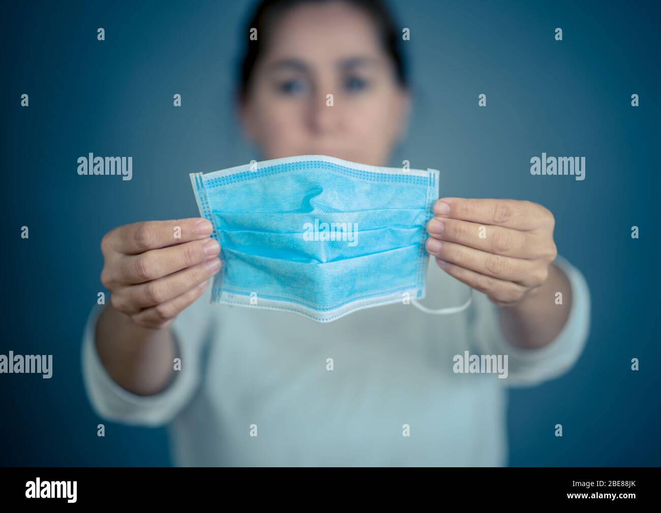 Coronavirus disease outbreak. Hand holding face surgical mask. Stop the ...