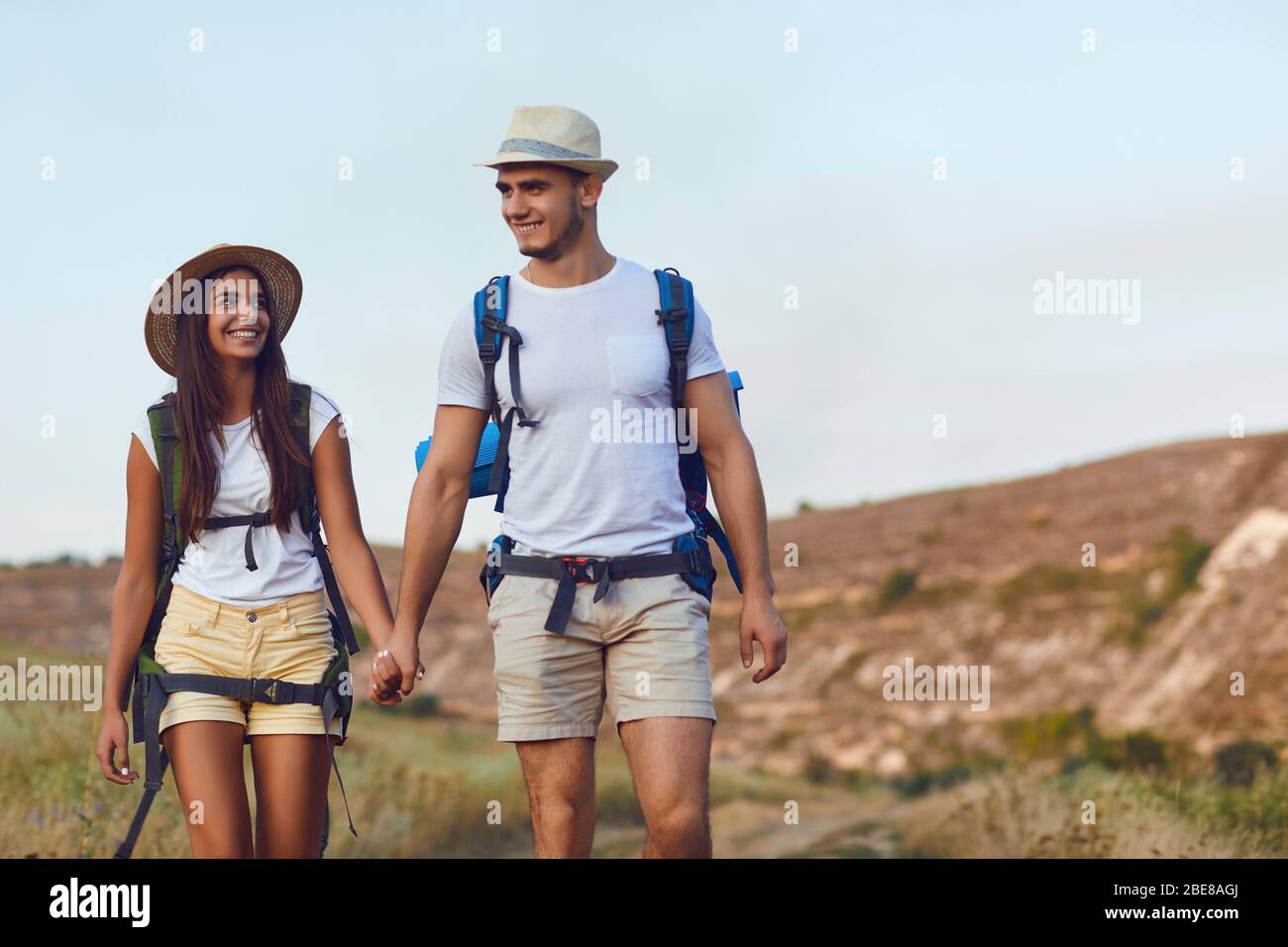 Happy hiking couple with backpack walking on hike in nature.Backpacker camping traveler trip ...