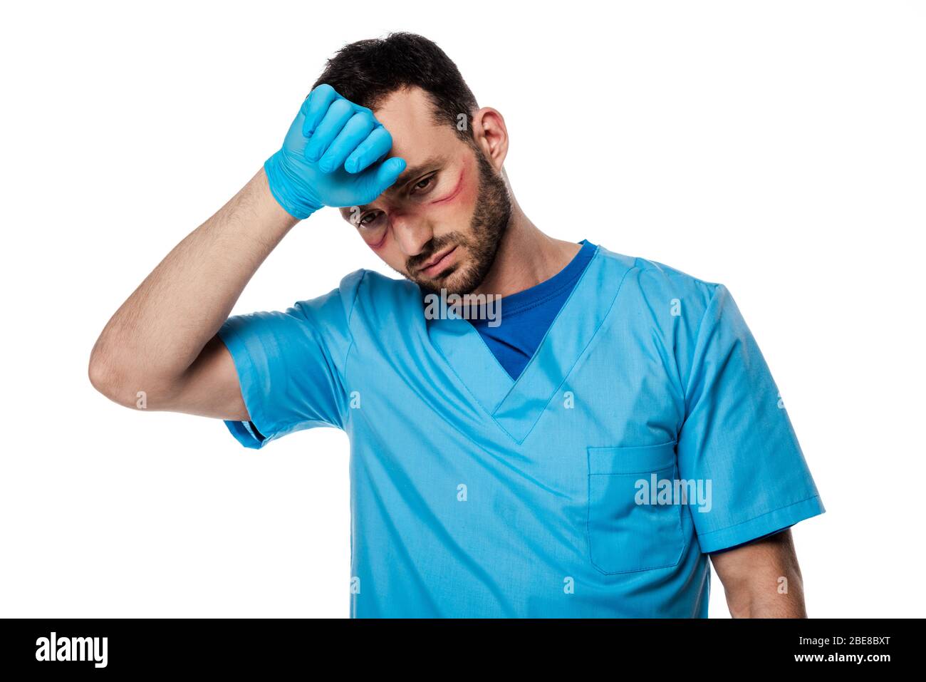 tired doctor with marks on face touching forehead isolated on white ...