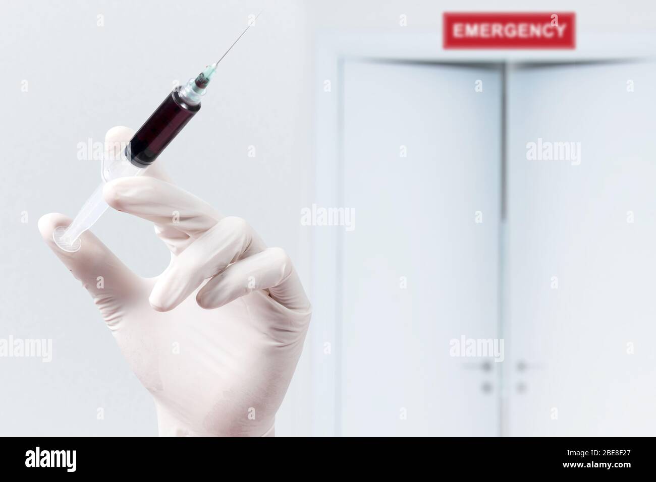 Doctor man in protective gloves holding a syringe on the emergency room ...