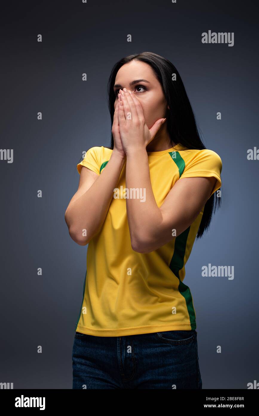scared female football fan covering face on grey Stock Photo - Alamy